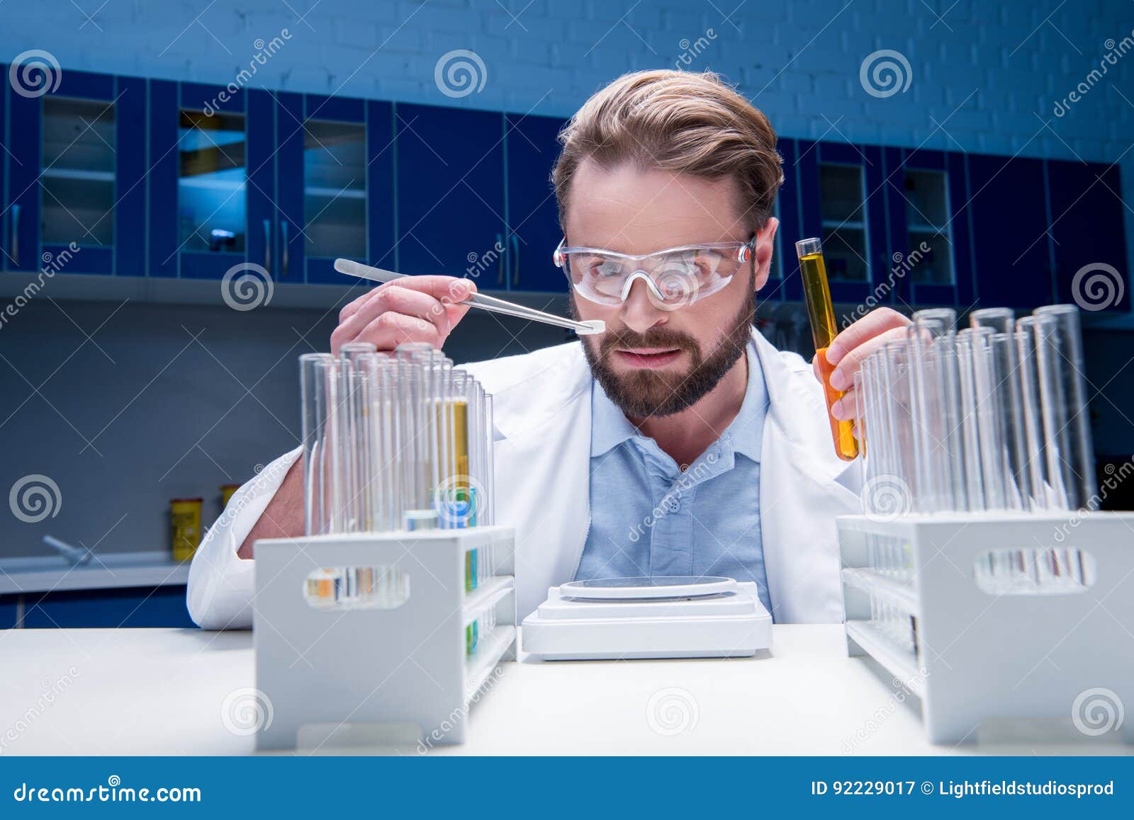 Chemist in Goggles with Reagents in Tubes and Tablet in Laboratory ...
