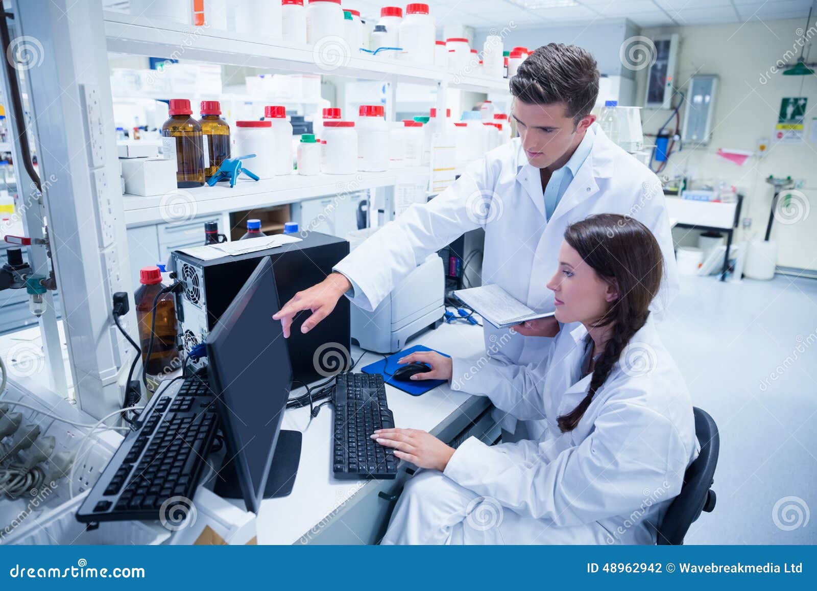 Chemist Team Working Together at Desk Using Computer Stock Photo ...