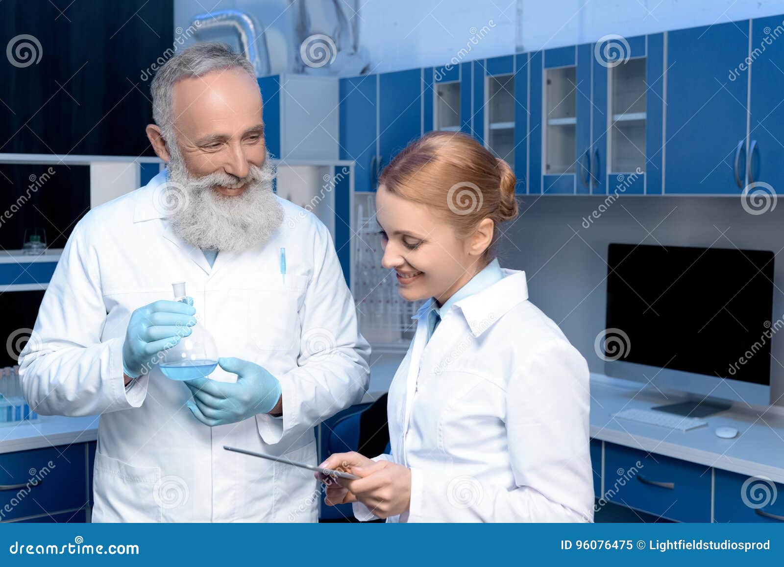 Chemists in Lab Coats Holding Flask and Digital Tablet at Laboratory ...