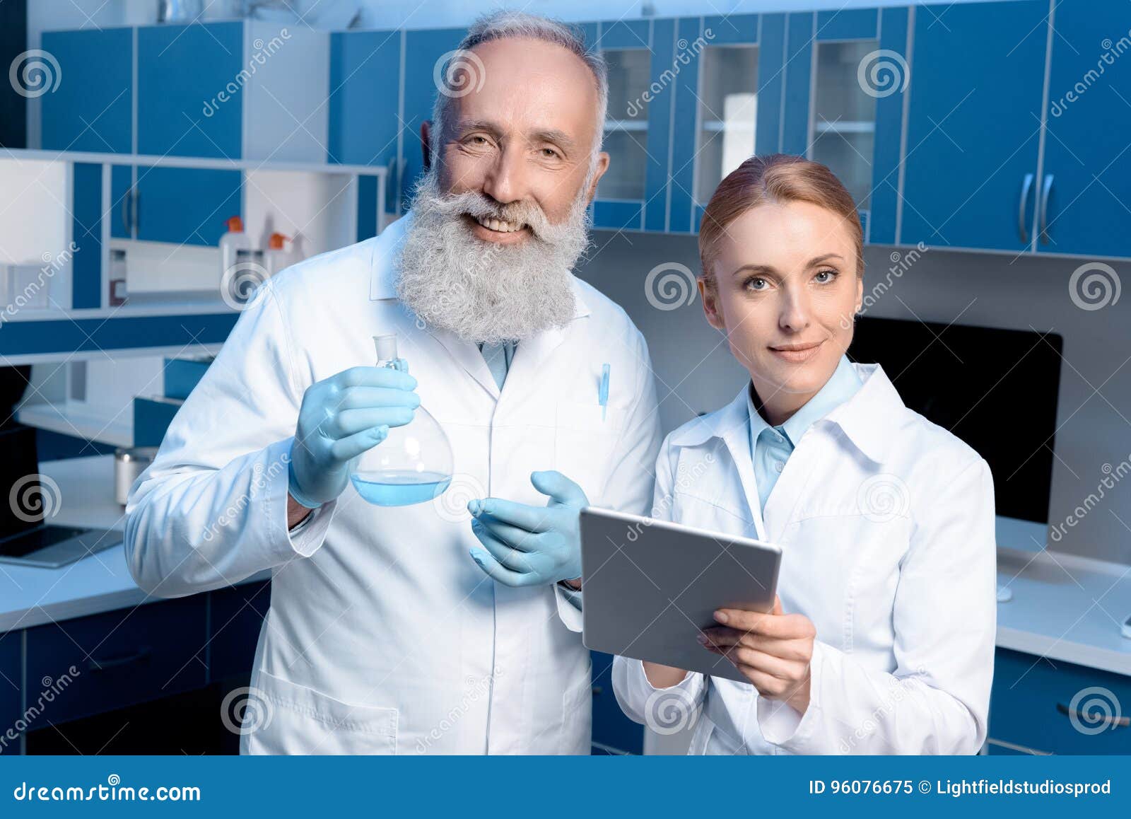 Chemists in Lab Coats Looking at Camera and Holding Flask and Digital ...