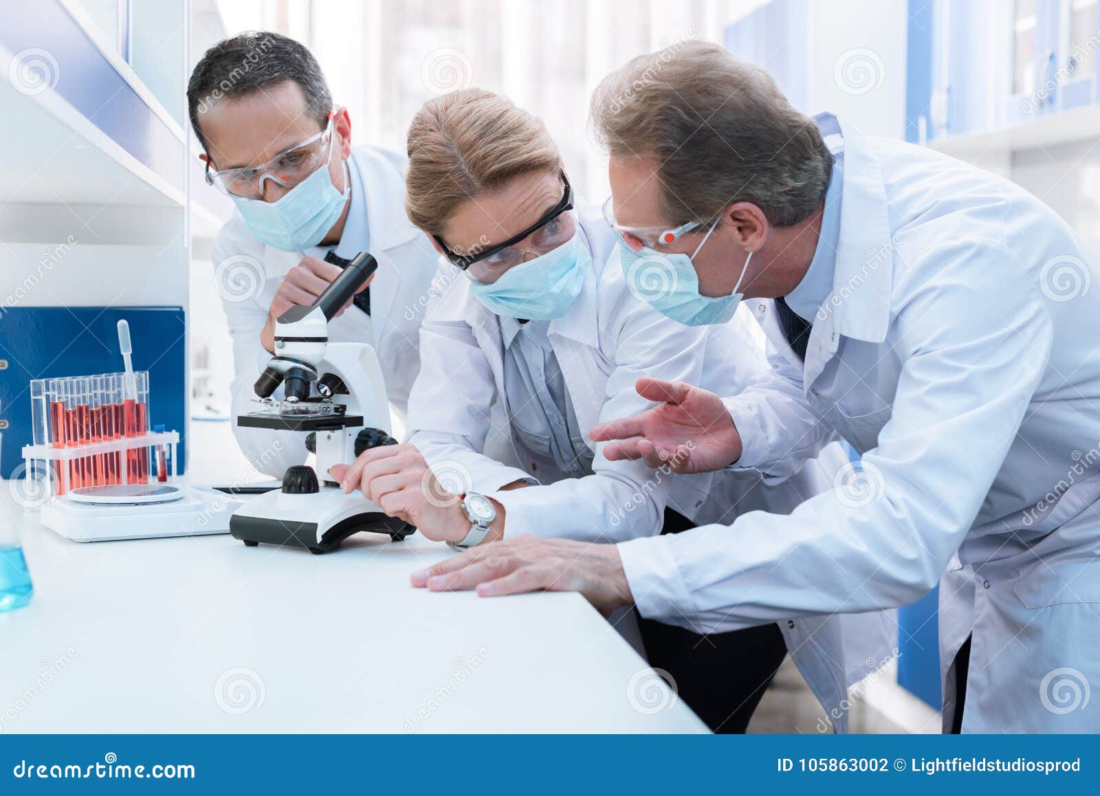 Chemists Using Microscope and Discussing Stock Photo - Image of ...