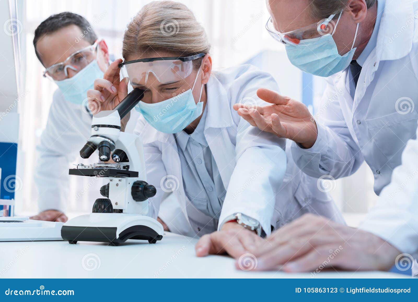 Chemists using microscope stock image. Image of teamwork - 105863123
