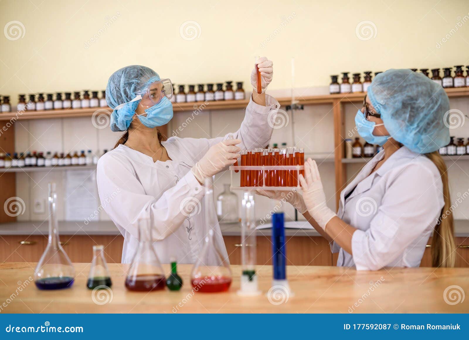 Chemists Working in Laboratory. Young Women in Protective Uniforms with ...