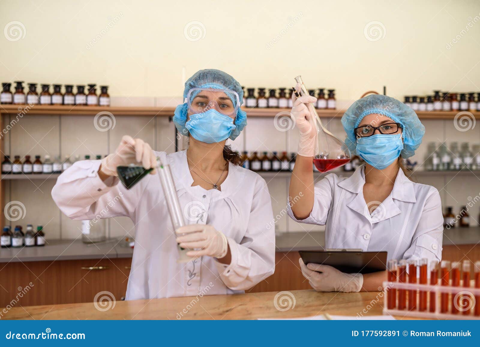 Chemists Working in Laboratory. Young Women in Protective Uniforms with ...
