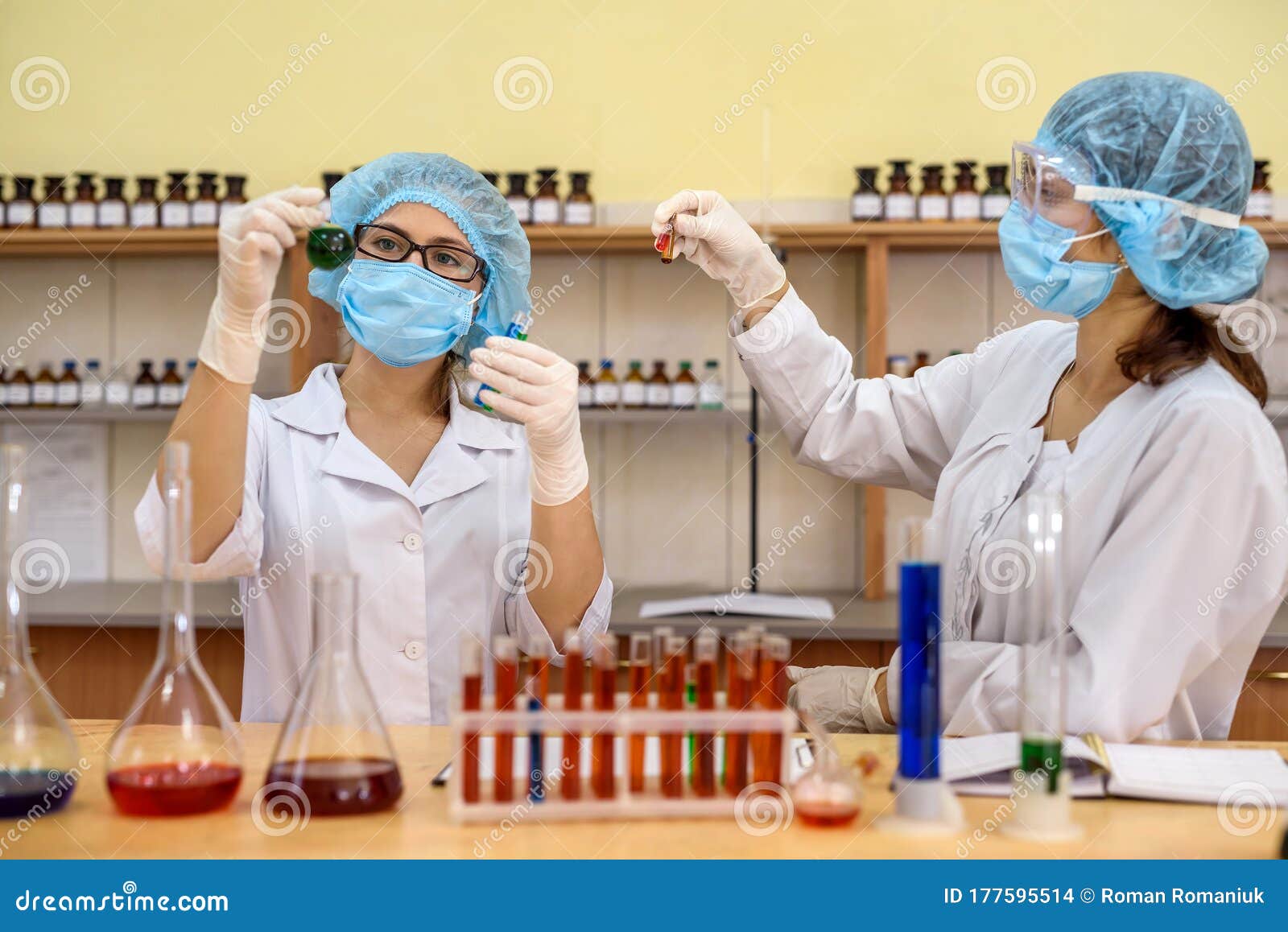 Chemists Working in Laboratory. Young Women in Protective Uniforms with ...