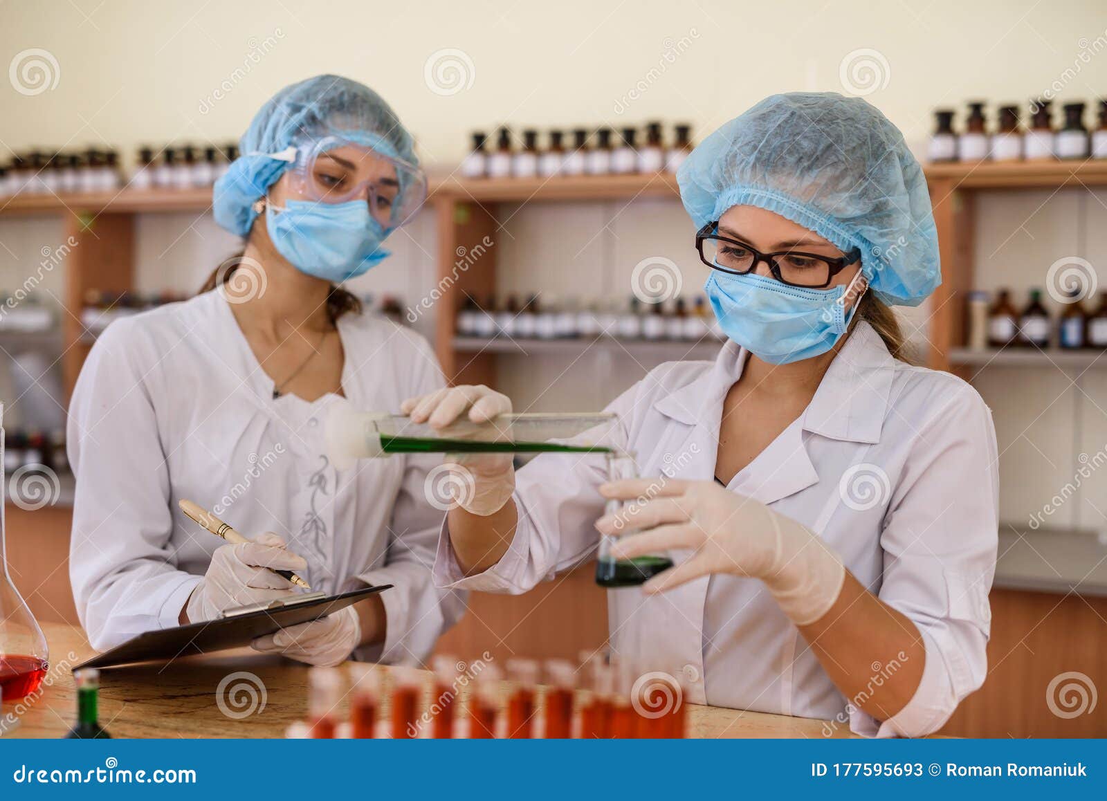 Chemists Working in Laboratory. Young Women in Protective Uniforms with ...