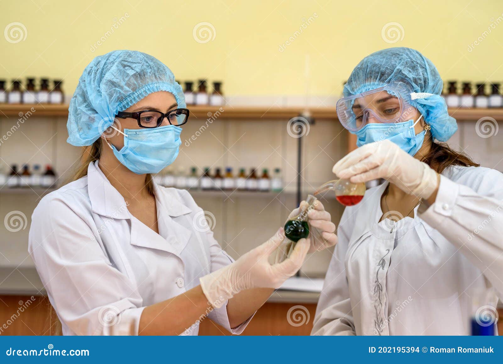 Chemists Working in Laboratory. Young Women in Protective Uniforms with ...