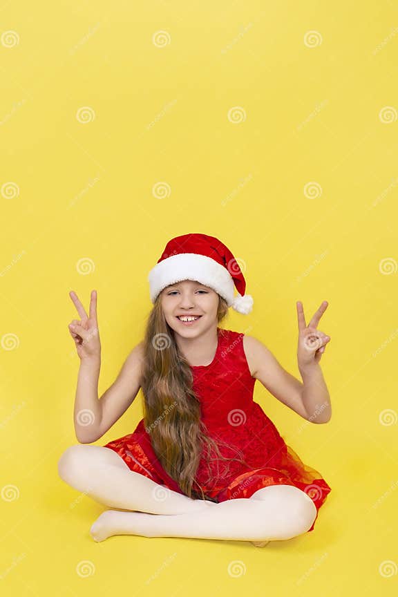Chica Adolescente En Vestido Rojo Y Santa Claus Sombrero Rojo Sentado