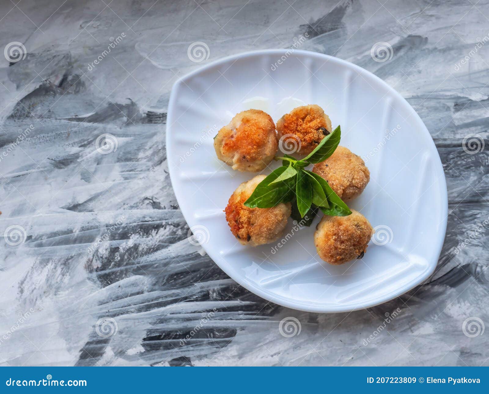 Chicken Meatballs with a Sprig of Basil on a White Curly Plate Stock ...