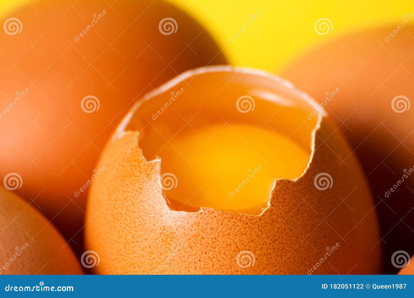Chicken Yolk in an Eggshell Macro Close-up, on Yellow Background Stock ...