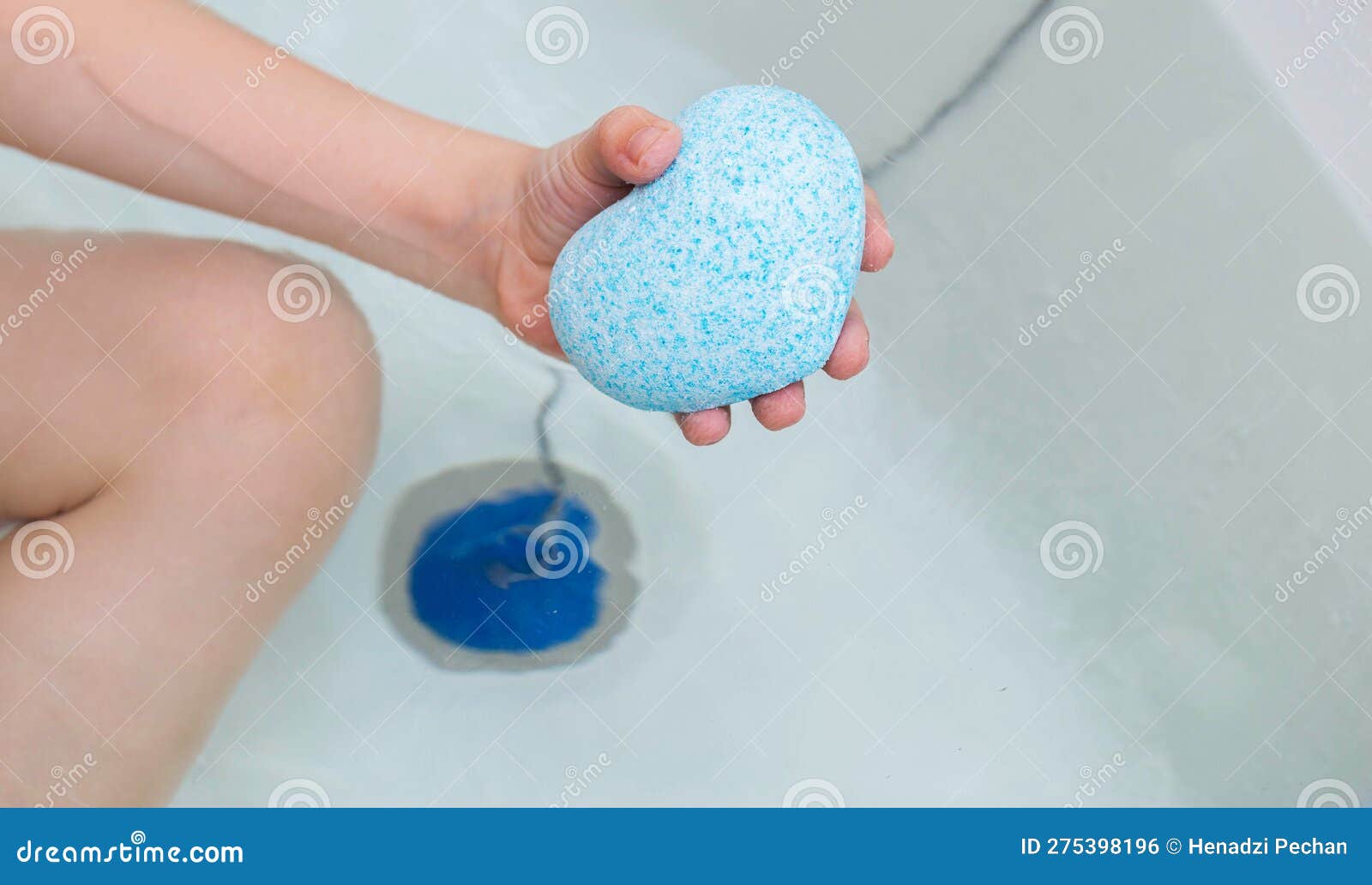 A Child in the Bath is Holding a Blue Bath Bomb with Coconut Extract ...