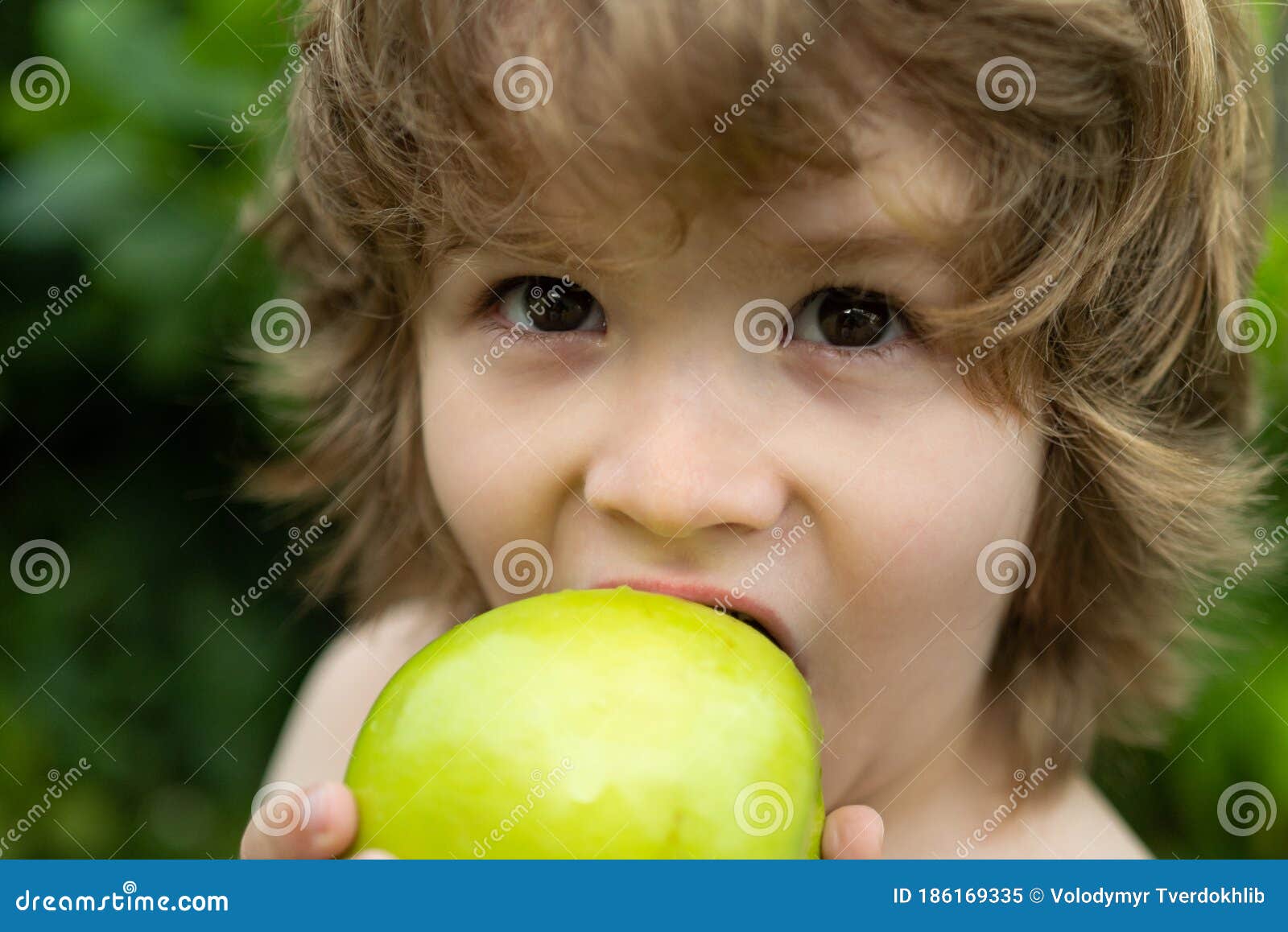 Child Boy Eating an Apple in a Park in Nature. Stock Image - Image of ...