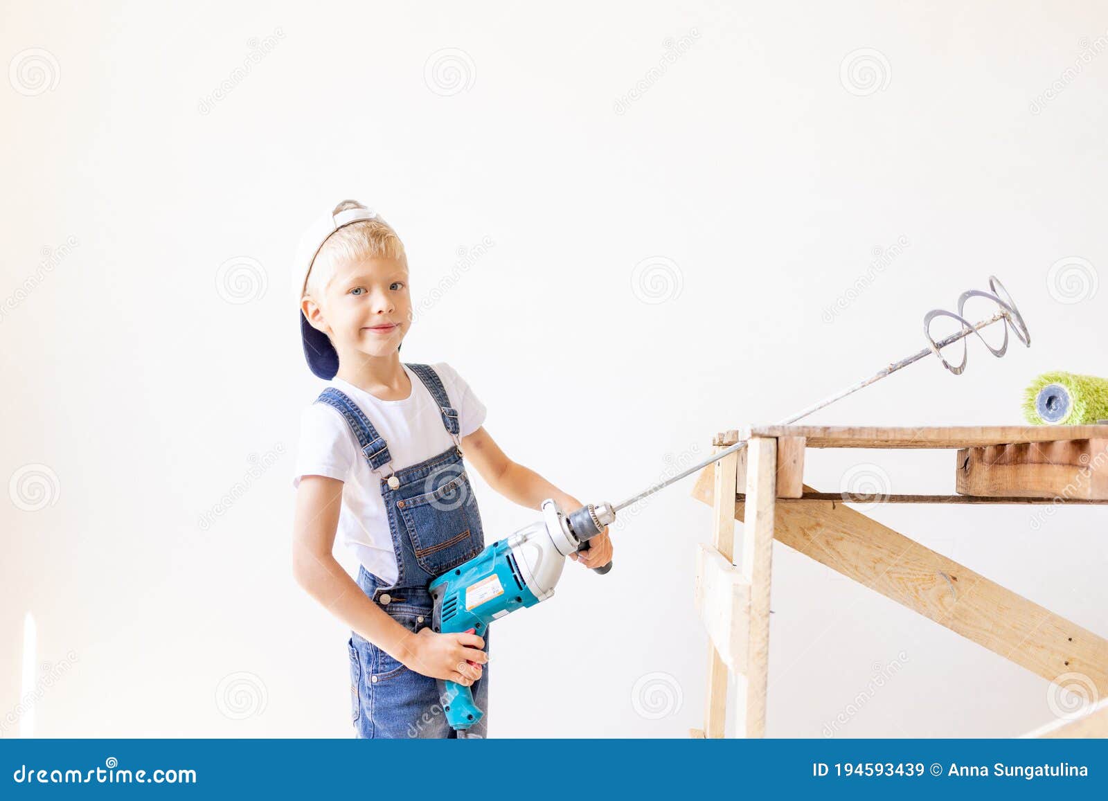 A Child Builder Holds a Construction Mixer Against the Background of a ...