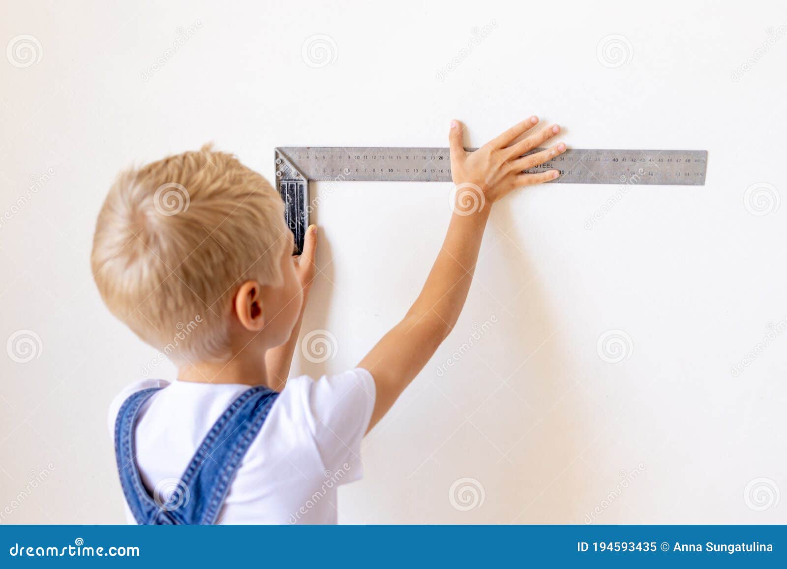 Child Builder Measures a White Wall with a Construction Ruler, Space ...