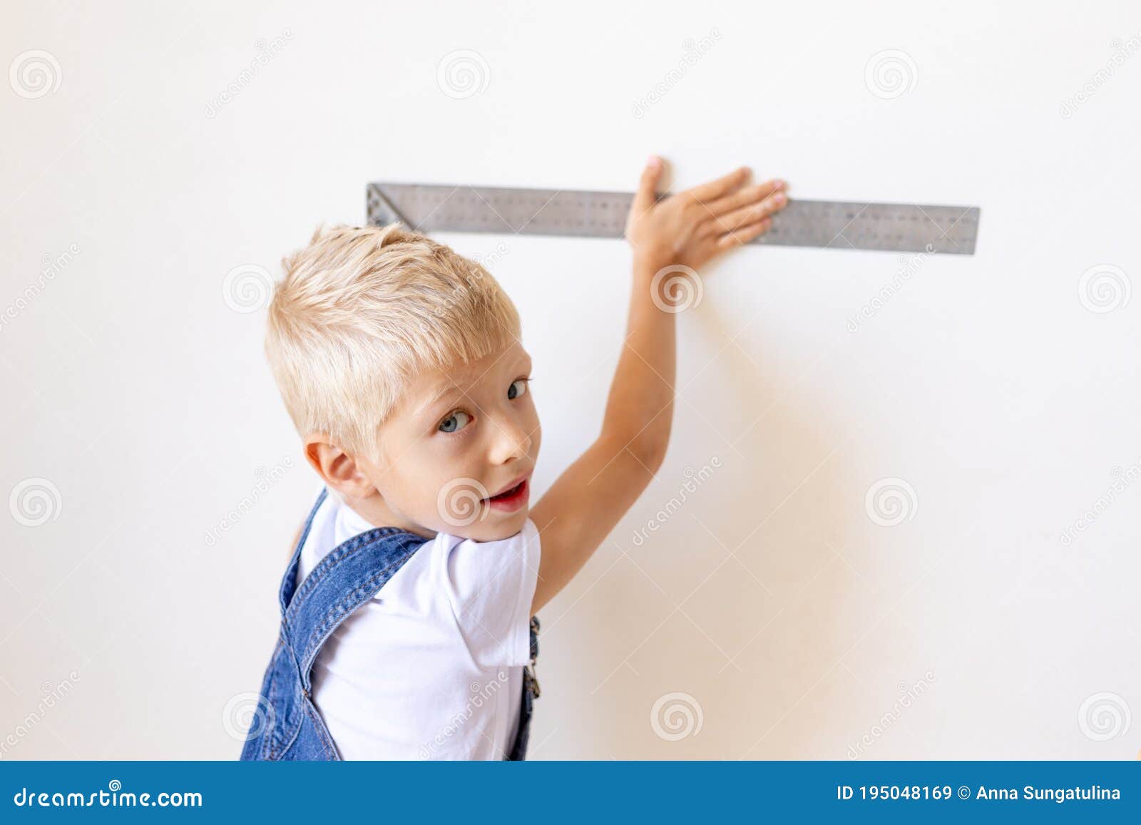 Child Builder Measures a White Wall with a Construction Ruler, Space ...