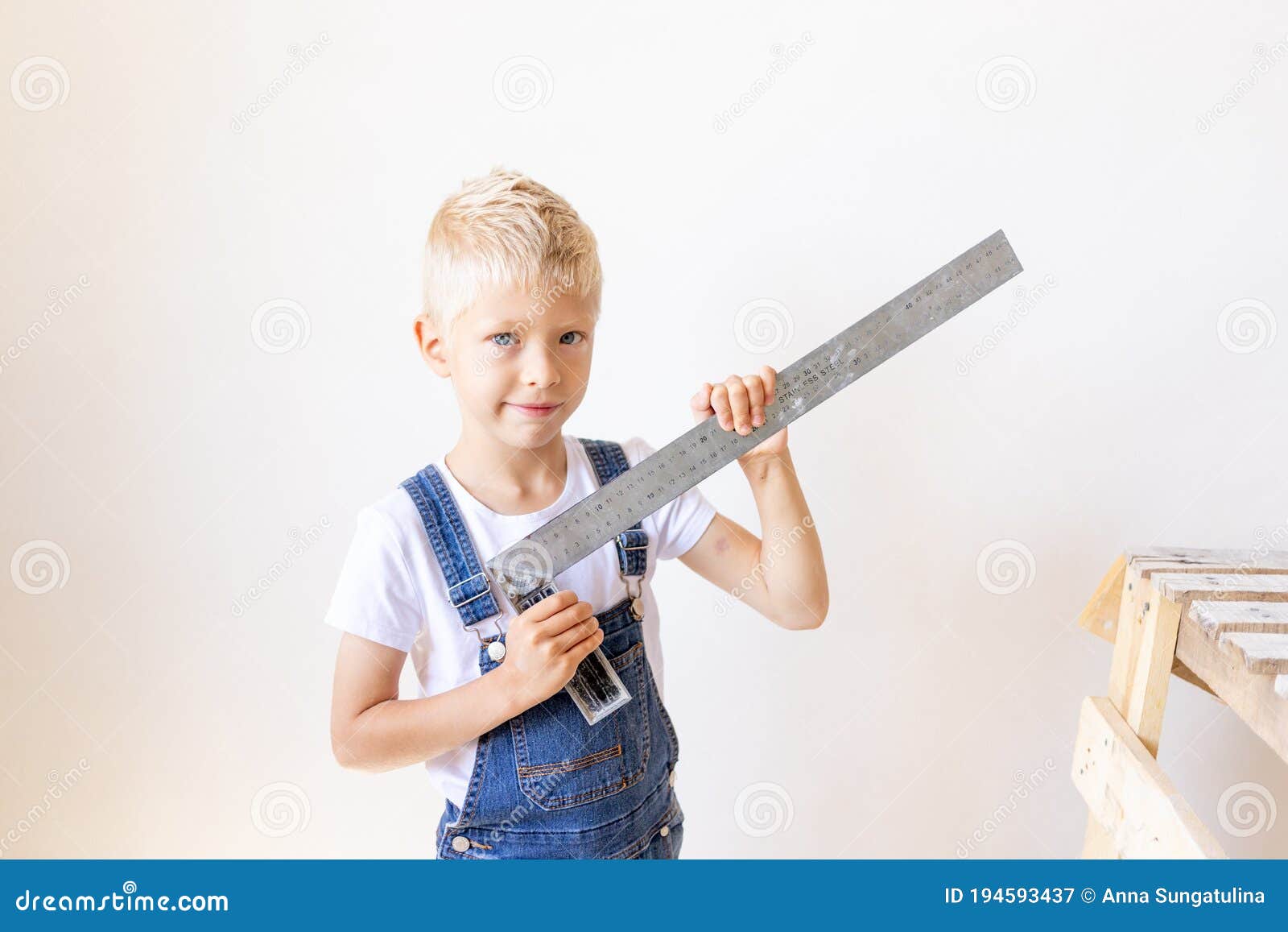 Child Builder Measures a White Wall with a Construction Ruler, Space ...