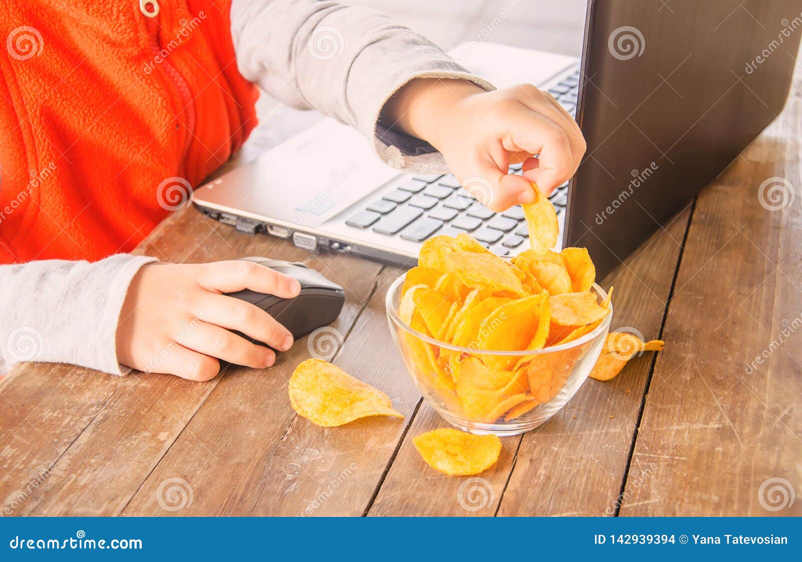 Child with Chips Behind a Computer. Selective Focus Stock Photo - Image ...