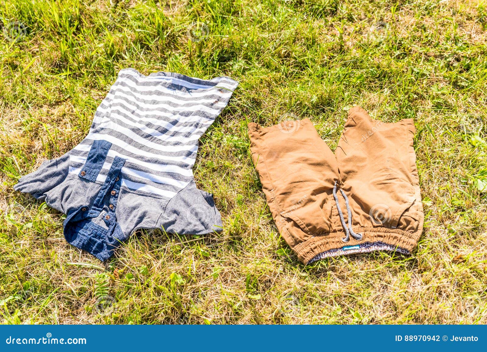 Child Clothes Laying on Grass Ground Under Bright Sun Stock Photo ...