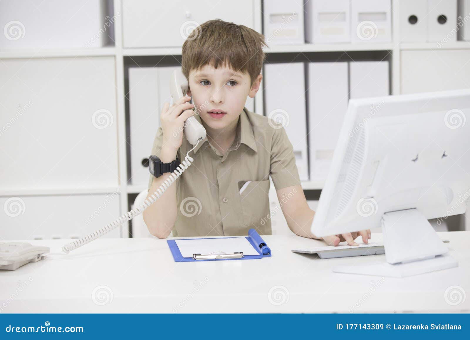 The Child at the Computer Holding the Phone Stock Image - Image of ...