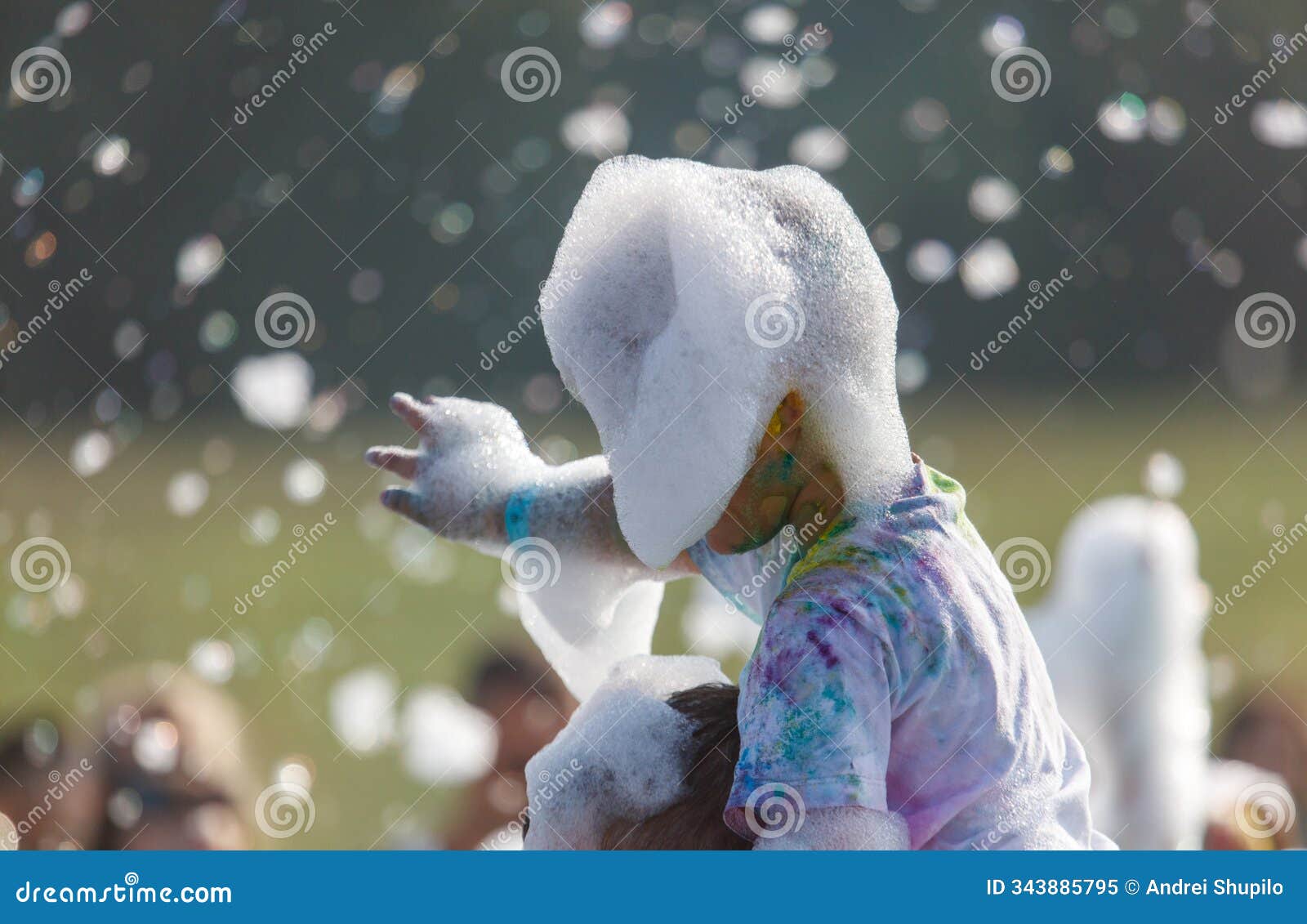 A Child is Covered in Foam and is Standing in a Crowd of People Stock ...