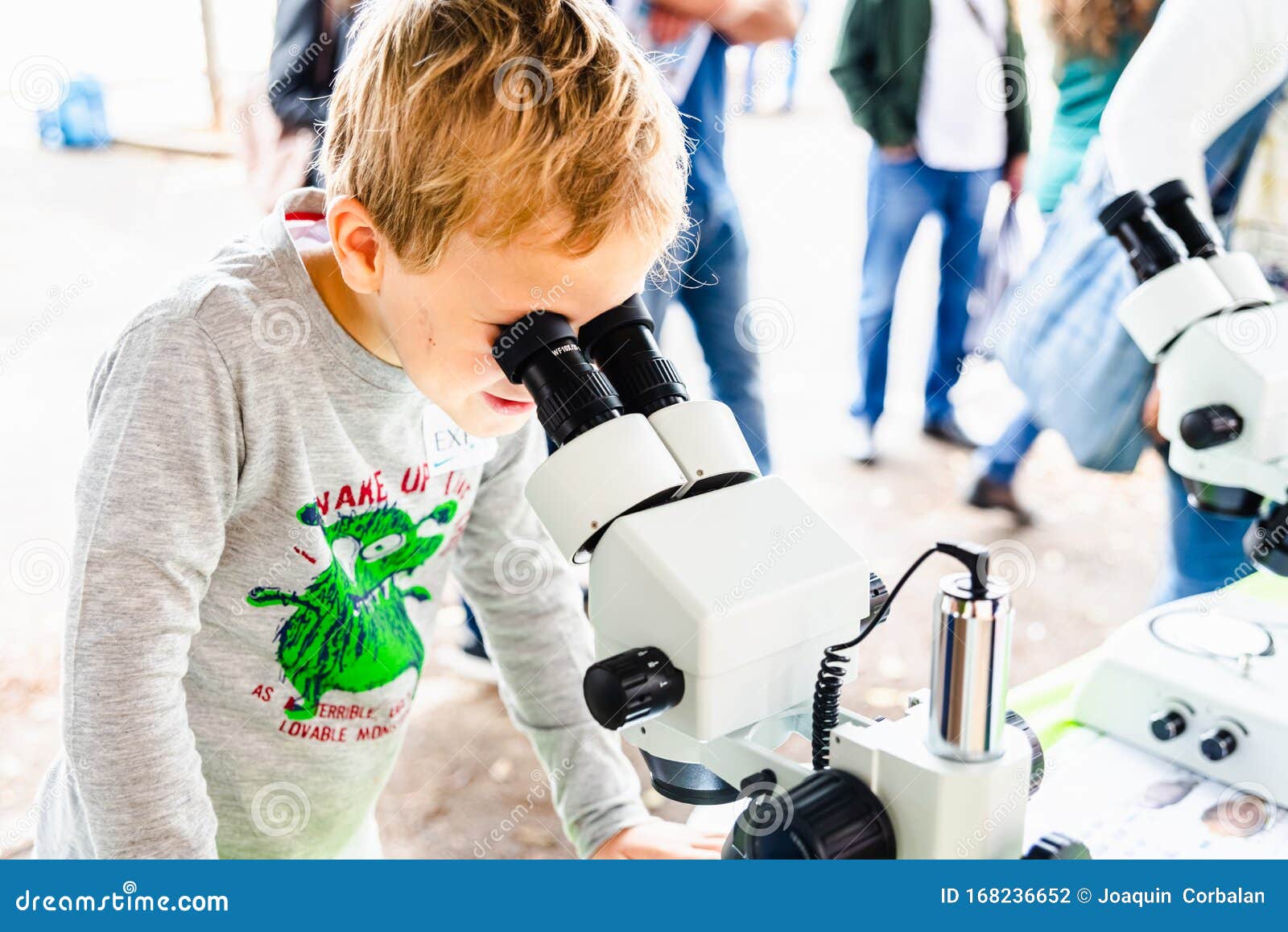 Child with Curiosity during a Medicine Fair Looking at Bacteria through ...