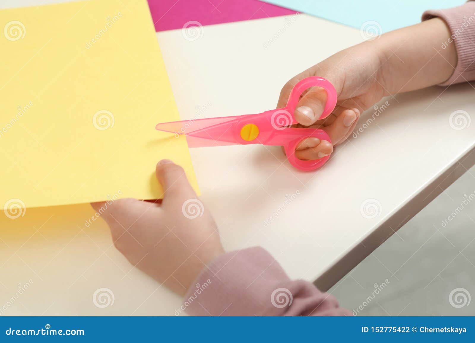 Child Cutting Color Paper with Plastic Scissors at Table Stock Photo ...