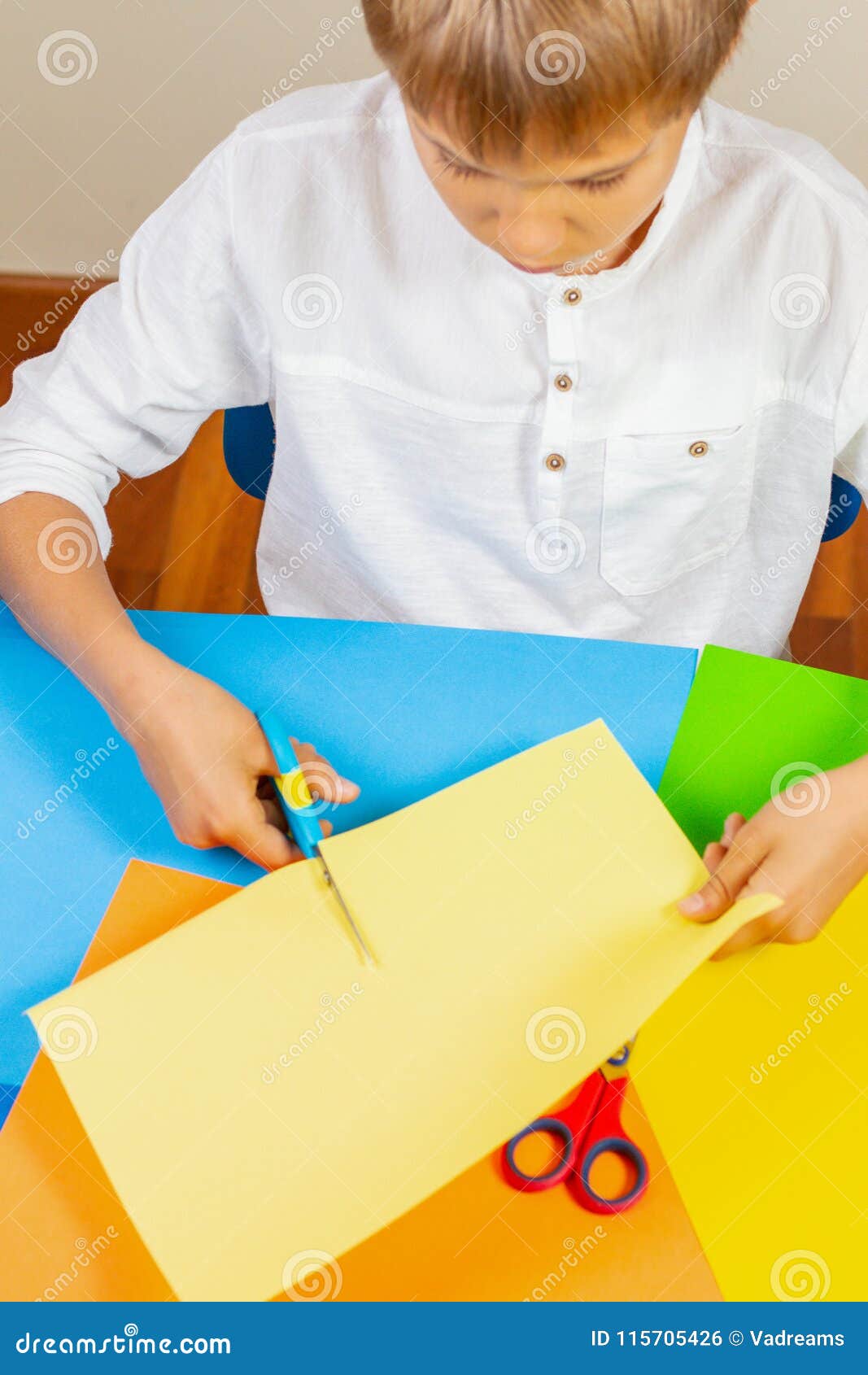 Child Cutting Colored Paper with Scissors at the Table Stock Photo ...