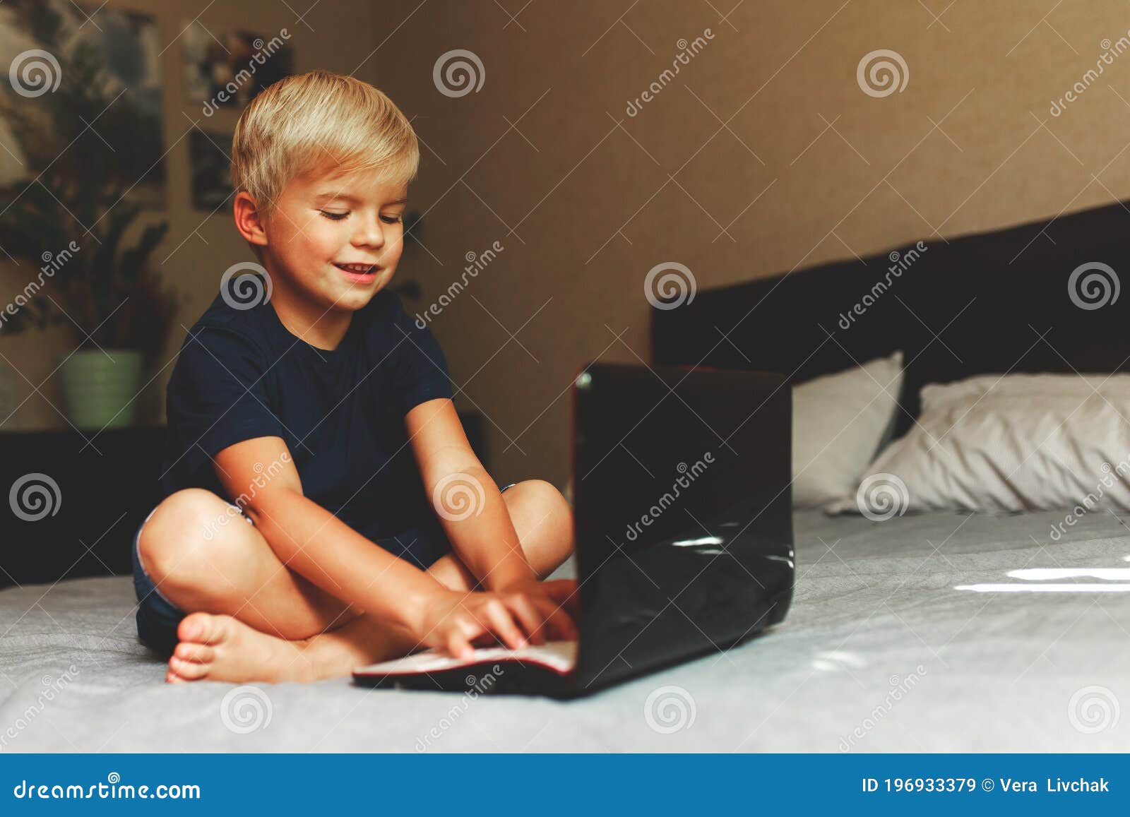 Child Does Homework , Lying in Bed Using His Laptop or Skyping. Stock ...