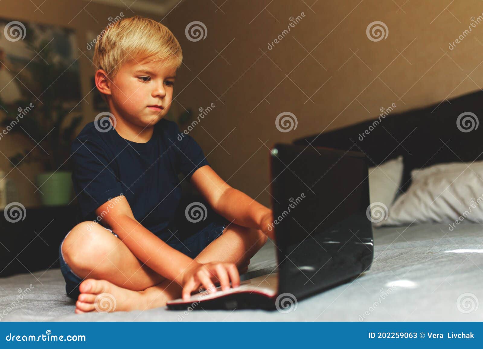 Child Does Homework , Lying in Bed Using His Laptop or Skyping. Stock ...