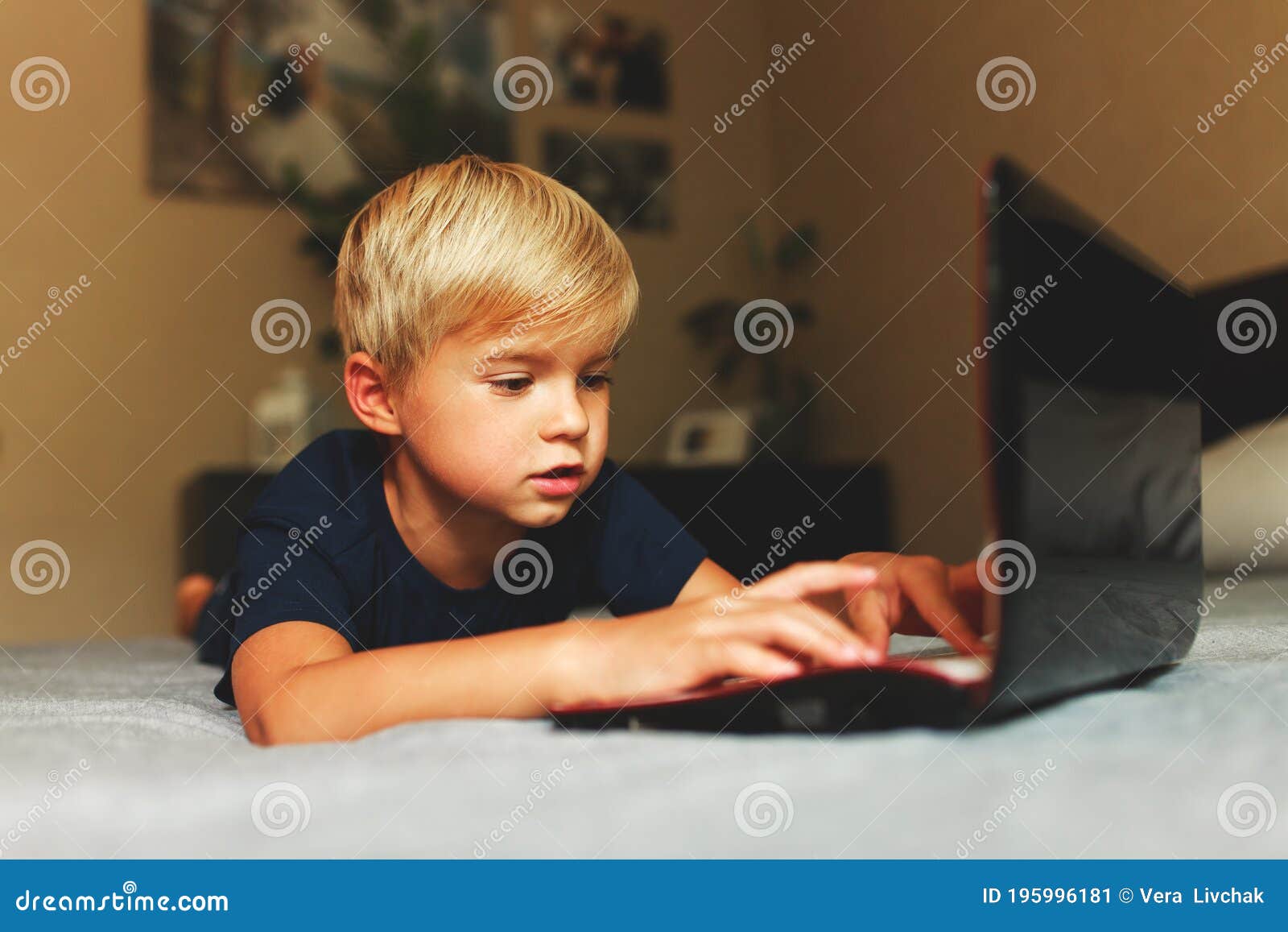Child Does Homework , Lying In Bed Using His Laptop Or Skyping. Stock ...