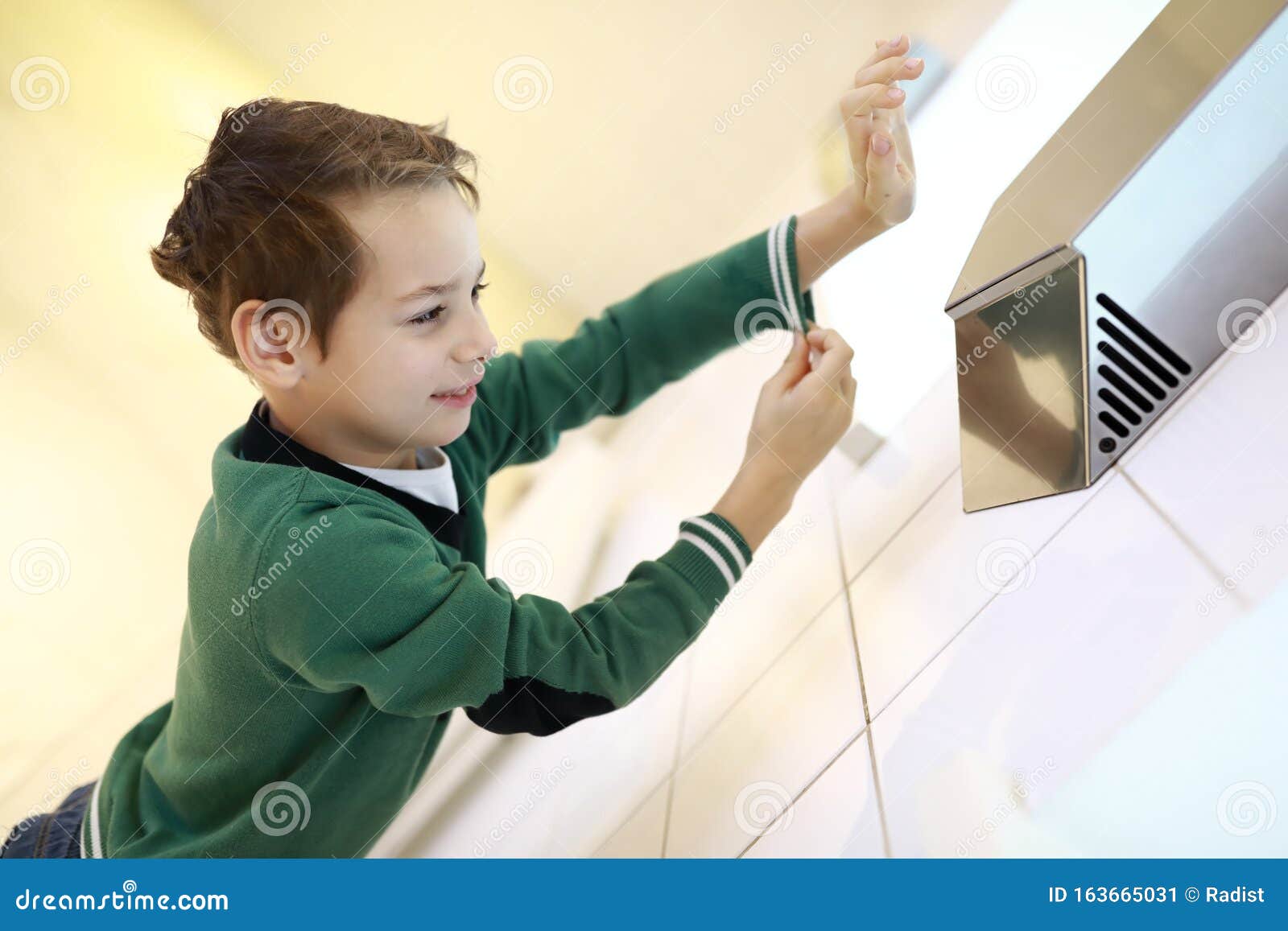 Child Dries Hands In An Electric Hand Dryer Stock Photo | CartoonDealer ...