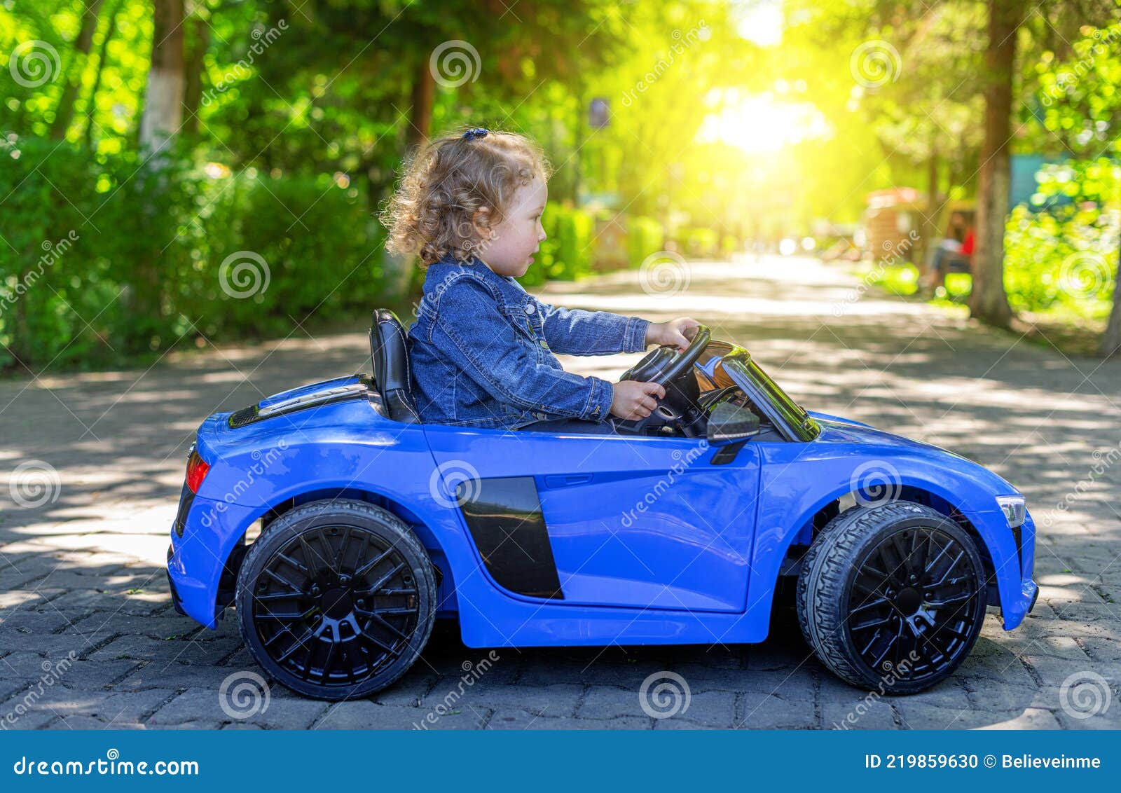 Child is Driving a Toy Car in the Park. Stock Photo - Image of portrait ...
