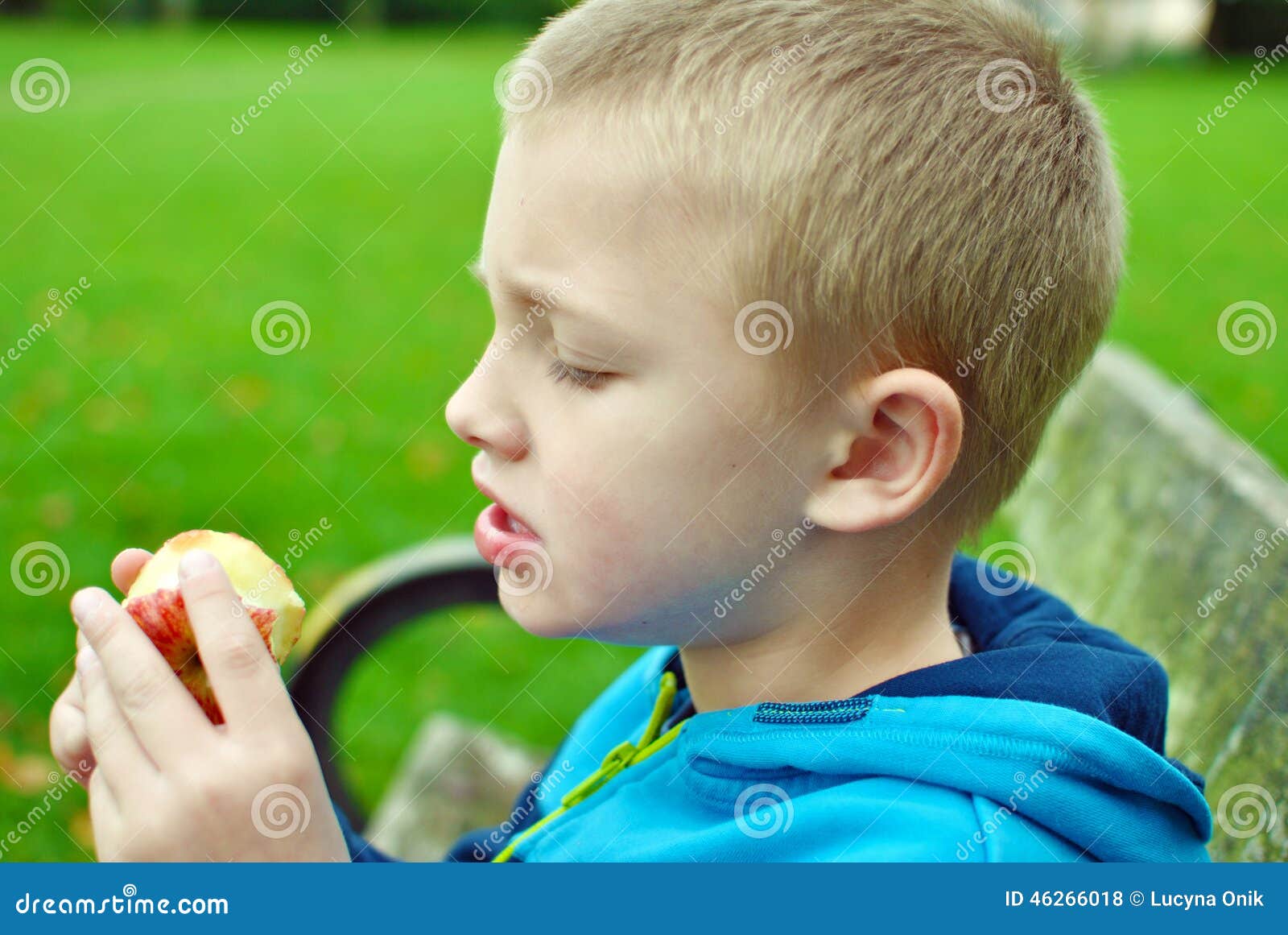 Child eating apple stock photo. Image of grass, bench - 46266018