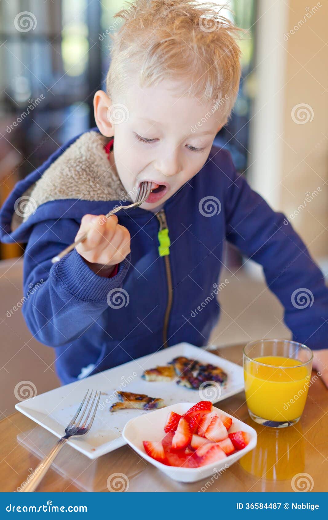Child eating breakfast stock image. Image of cafe, glass - 36584487