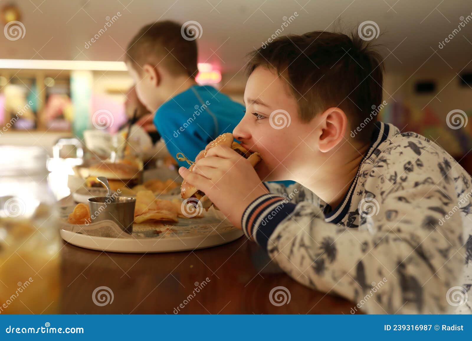 Child eating burger at bar stock image. Image of caucasian - 239316987
