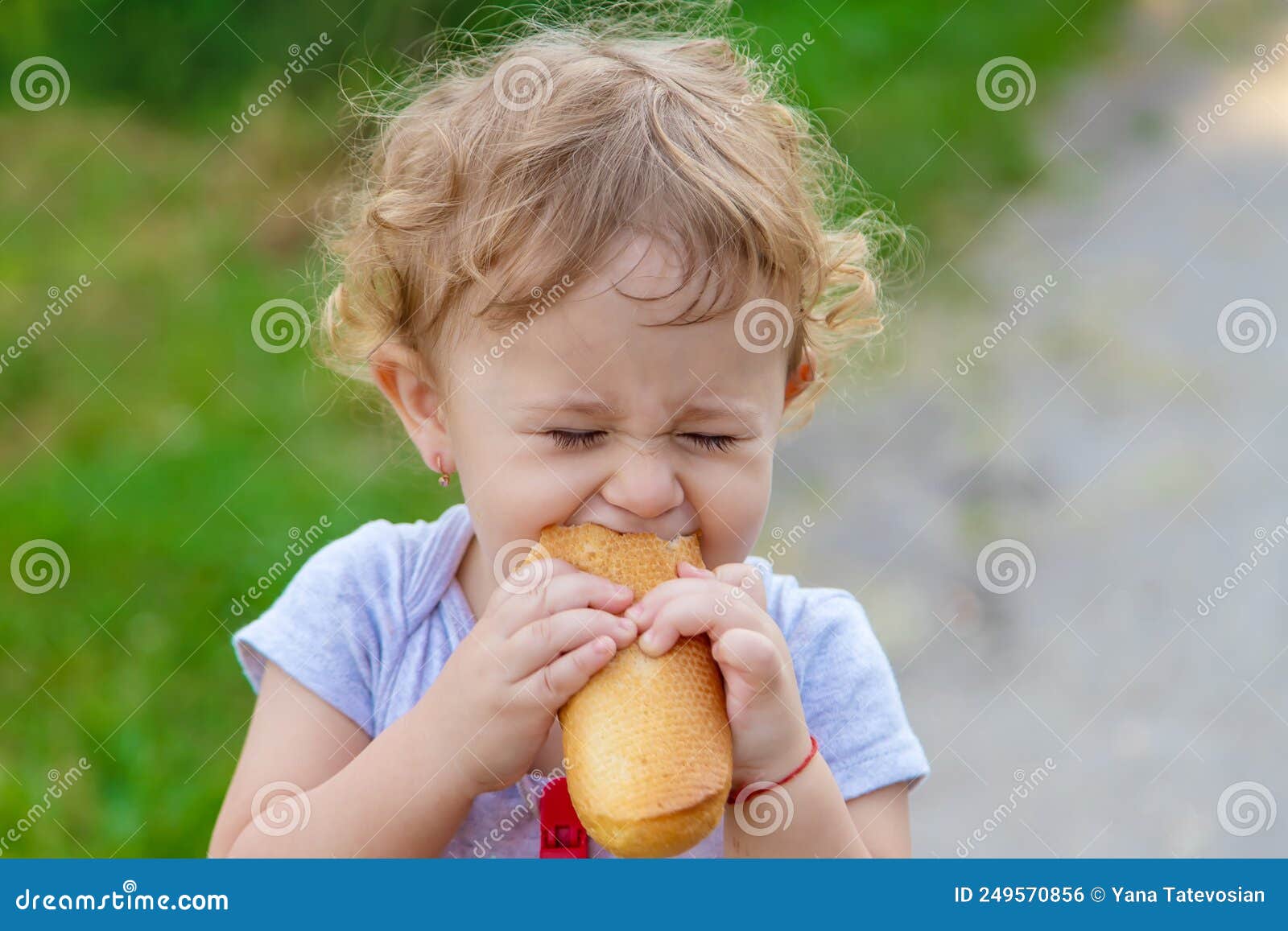 A Child Eats Bread in the Park. Selective Focus Stock Photo - Image of ...