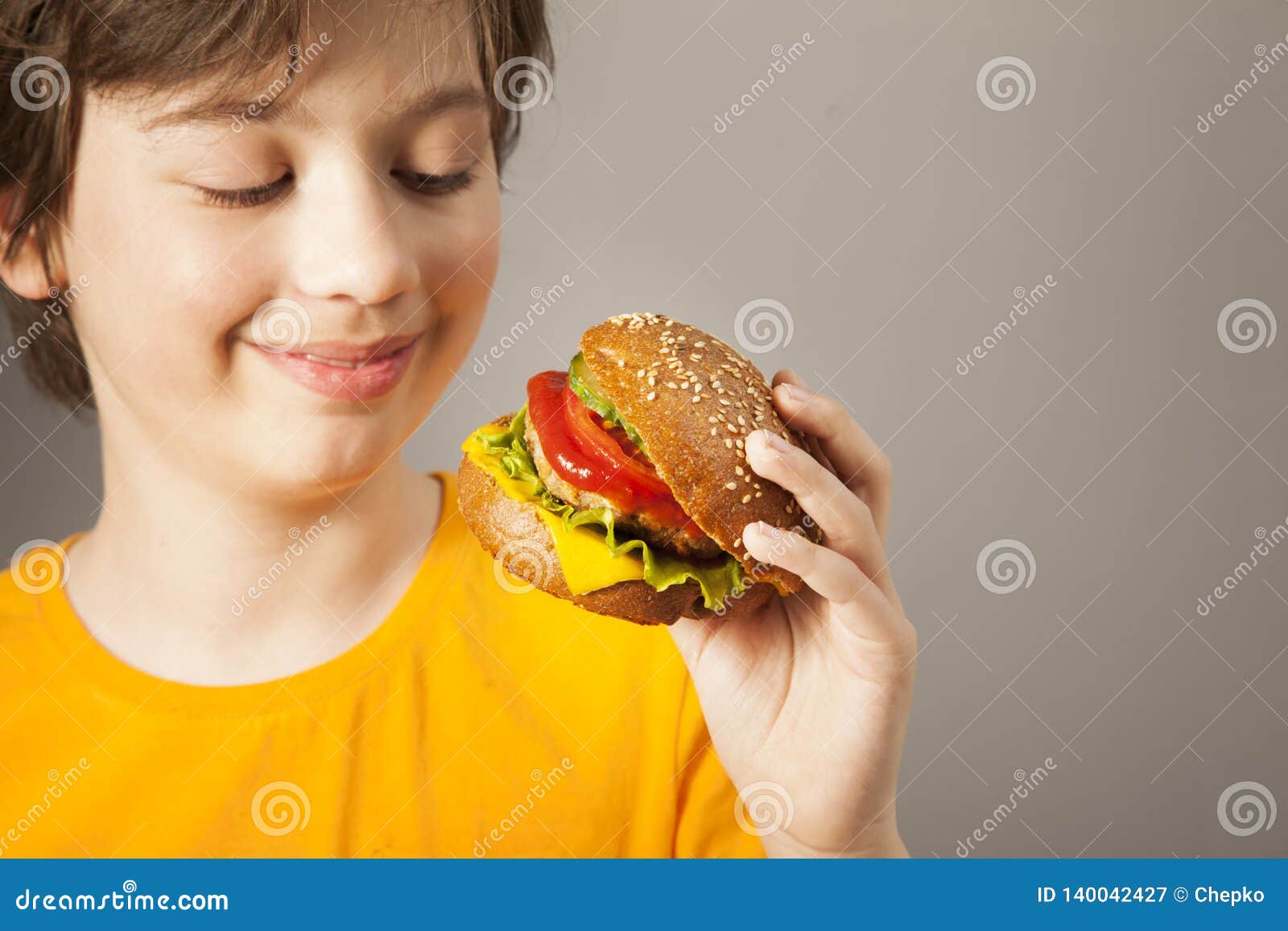 Child Eats Burger on Grey Background. Male Child with Hamburger Stock ...