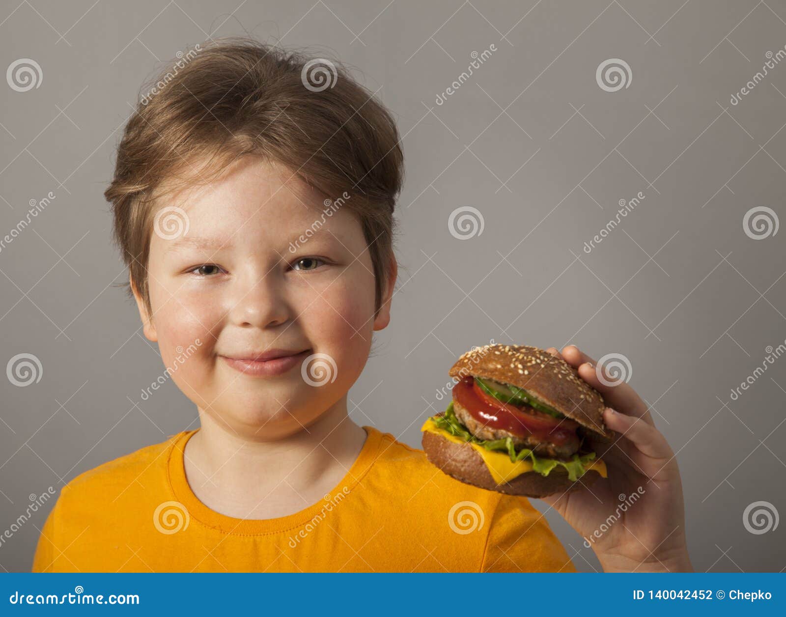 Child Eats Burger on Grey Background. Male Child with Hamburger Stock ...
