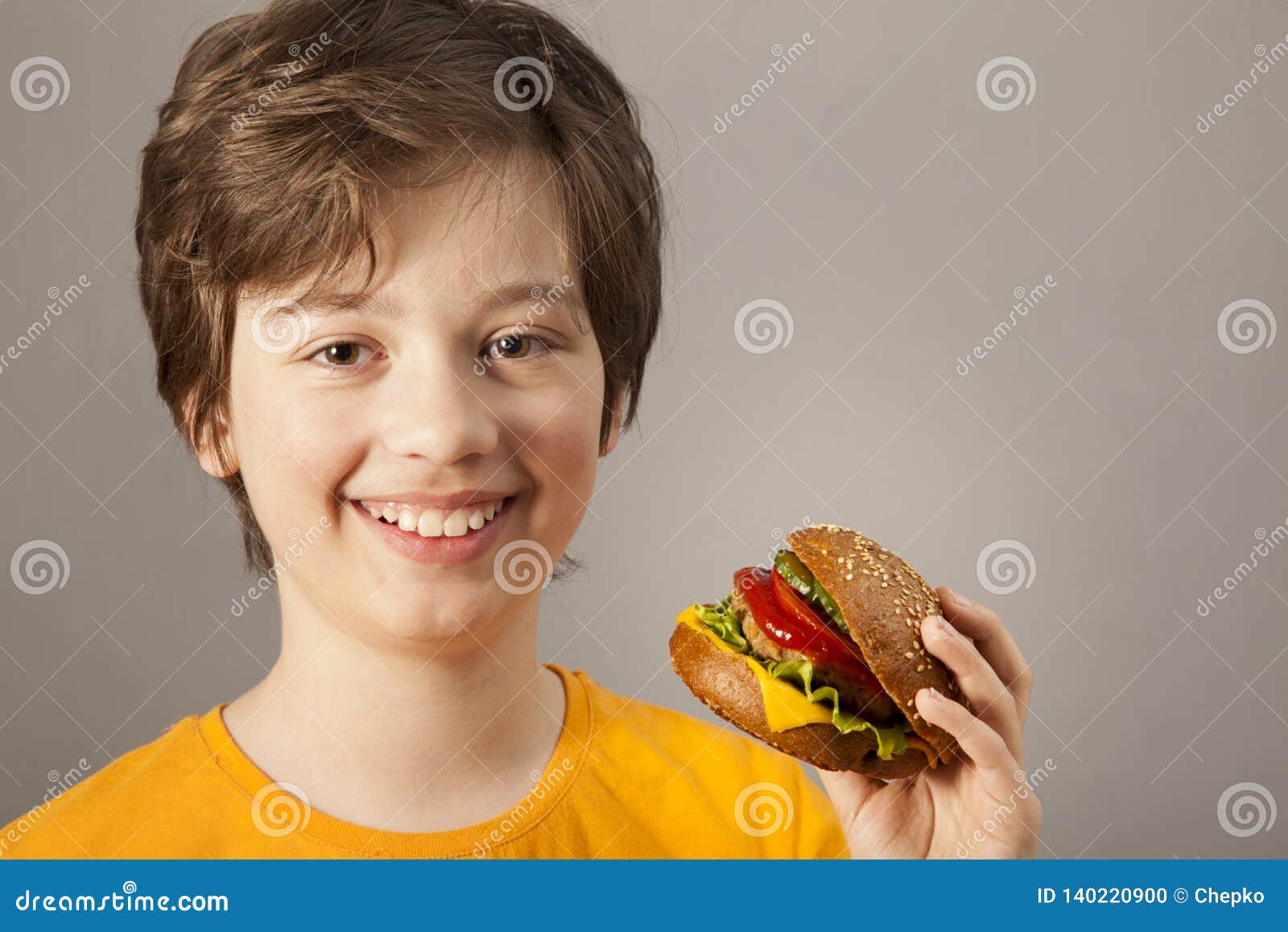 Child Eats Burger on Grey Background. Male Child with Hamburger Stock ...