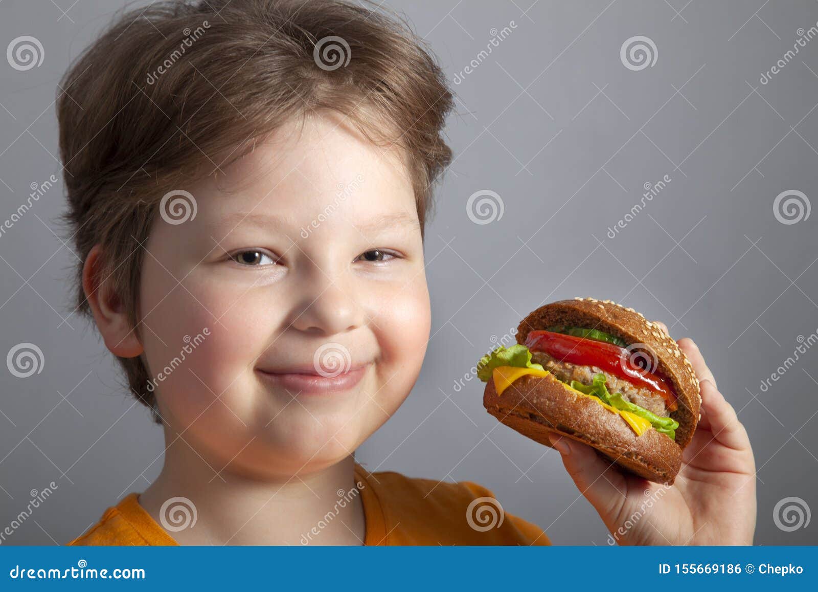 Child Eats Burger on Grey Background. Male Child with Hamburger Stock ...