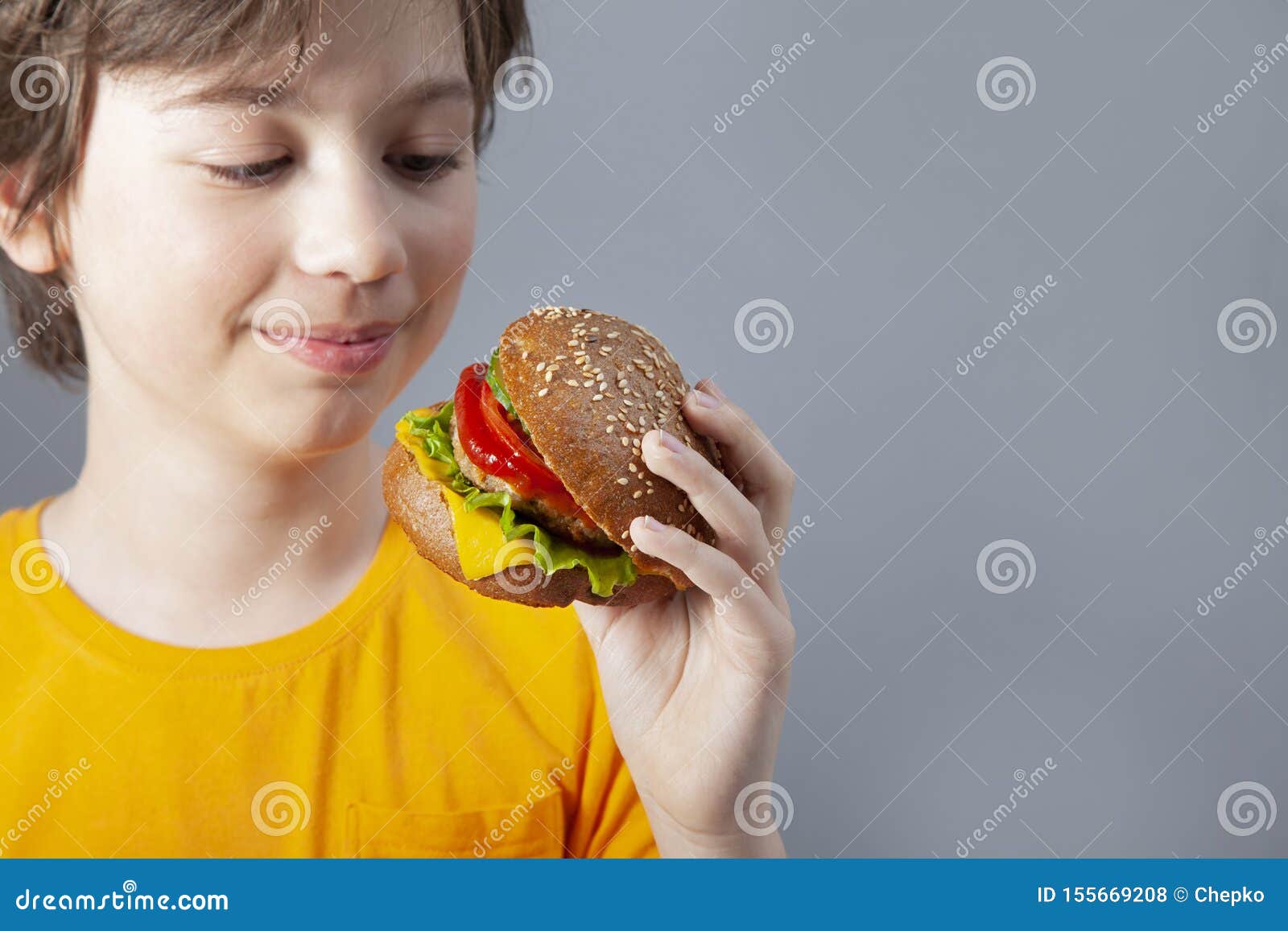 Child Eats Burger on Grey Background. Male Child with Hamburger Stock ...