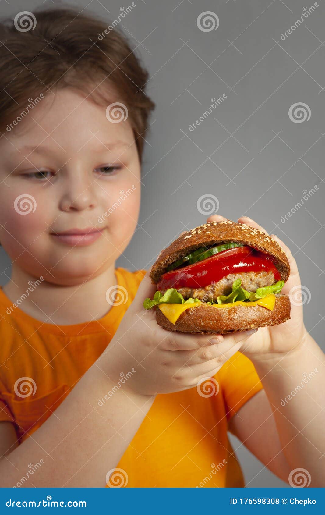 Child Eats Burger on Grey Background. Male Child with Hamburger Stock ...