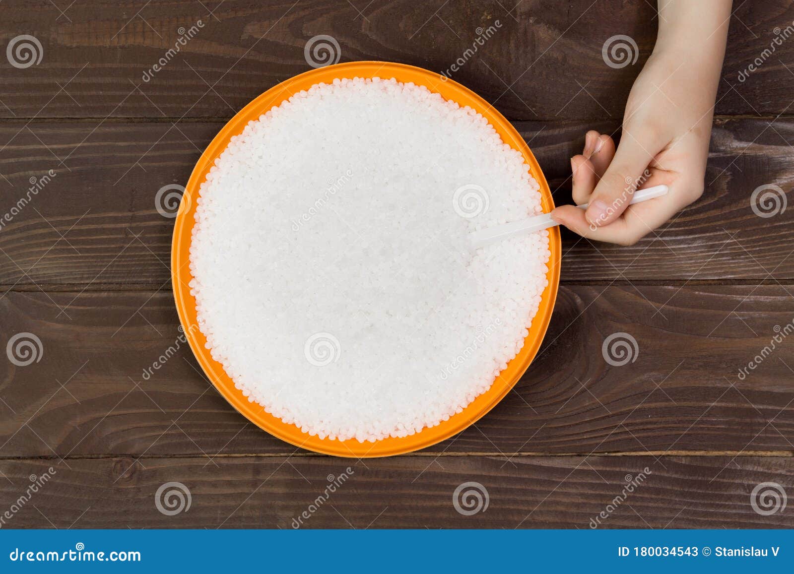 A Child Eats Plastic Pellets from a Plate .Concept of Environmental ...