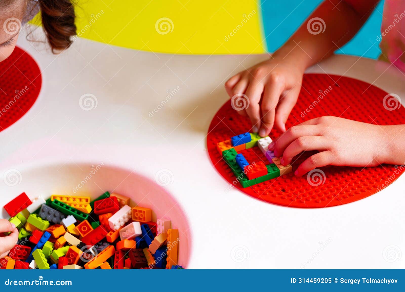 Child Engaged in Creative Play with Colorful Building Blocks on a Round ...