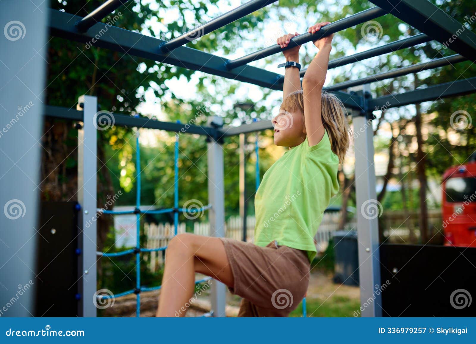 A Young Child Practicing Pull-ups at a Playground in the Late Afternoon ...