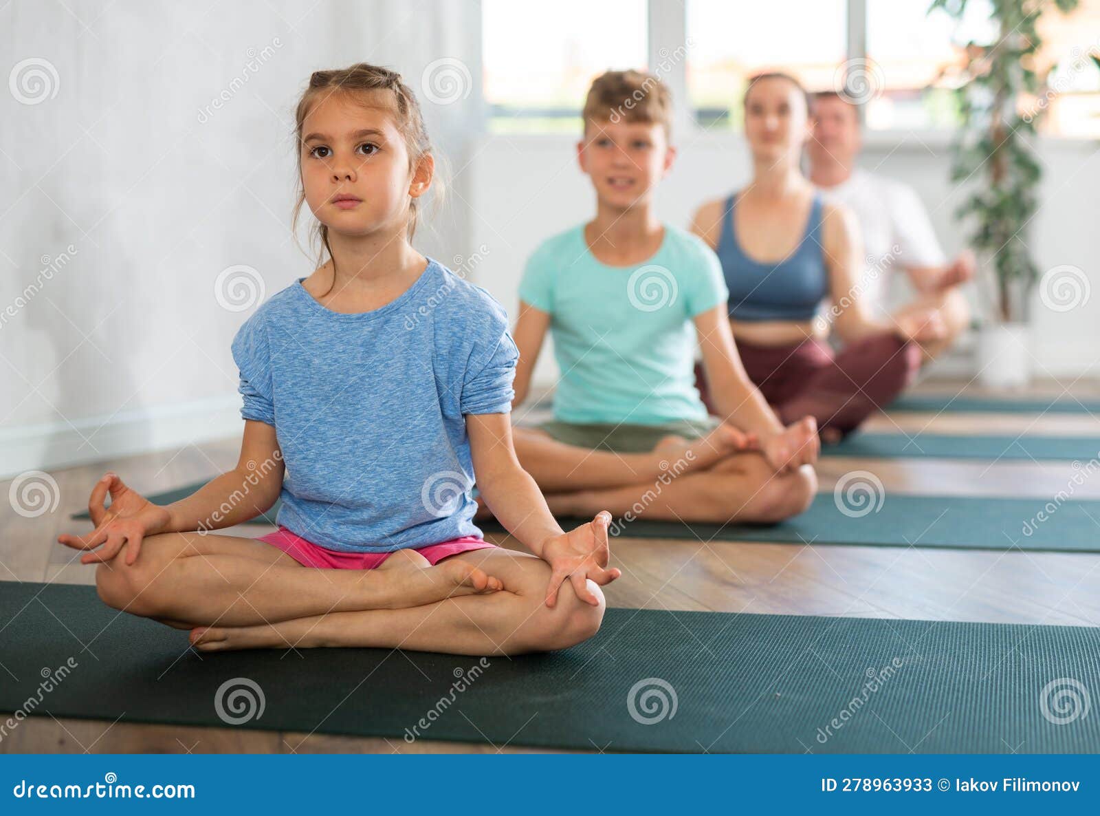 Child with Family Performs Lotus Pose, Folding Fingers in Mudra of ... Child with Family Performs Lotus Pose, Folding Fingers in Mudra of ...