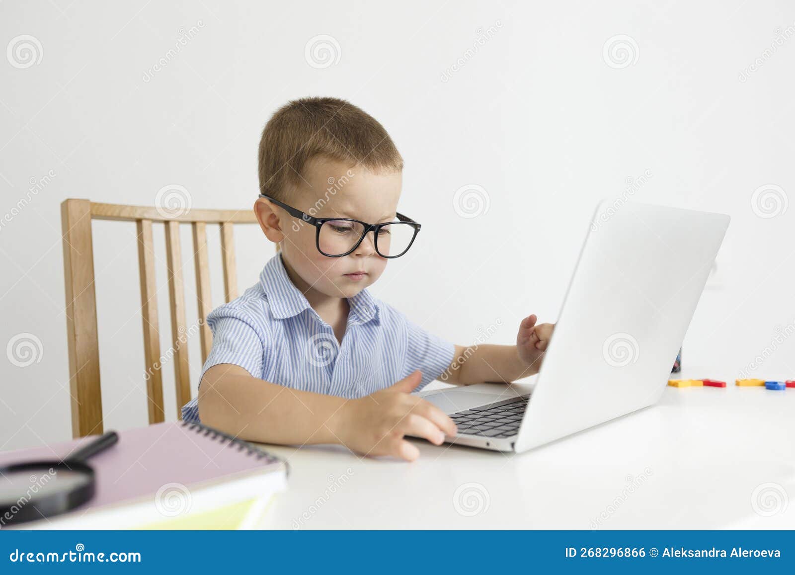A Child with Glasses is Focused on Completing a Task. the Child Does ...