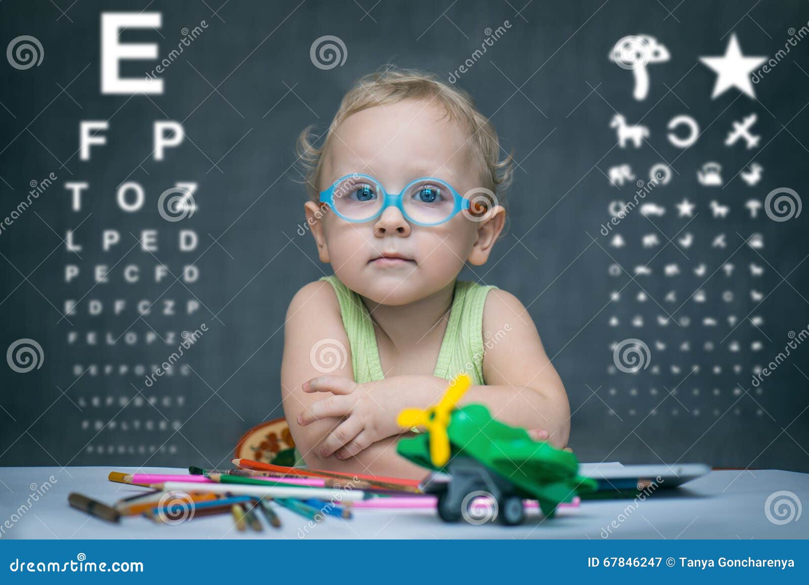 Child with Glasses Sits at a Table on the Background of the Table for ...