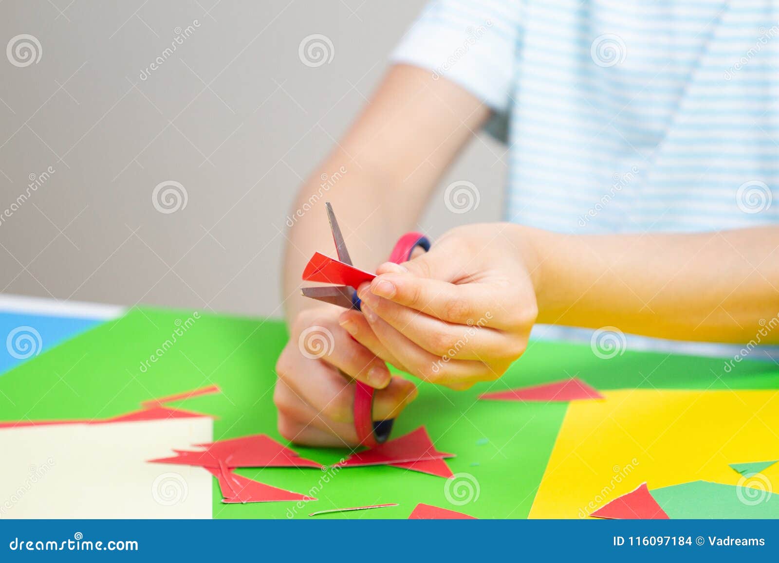 Child Hands Cutting Colored Paper with Scissors at the Table Stock ...