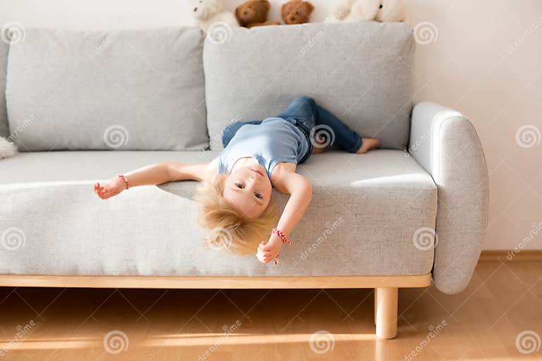 Child, Hanging Upside Down from a Couch at Home, Smiling Happily Stock ... Child, Hanging Upside Down from a Couch at Home, Smiling Happily Stock ...